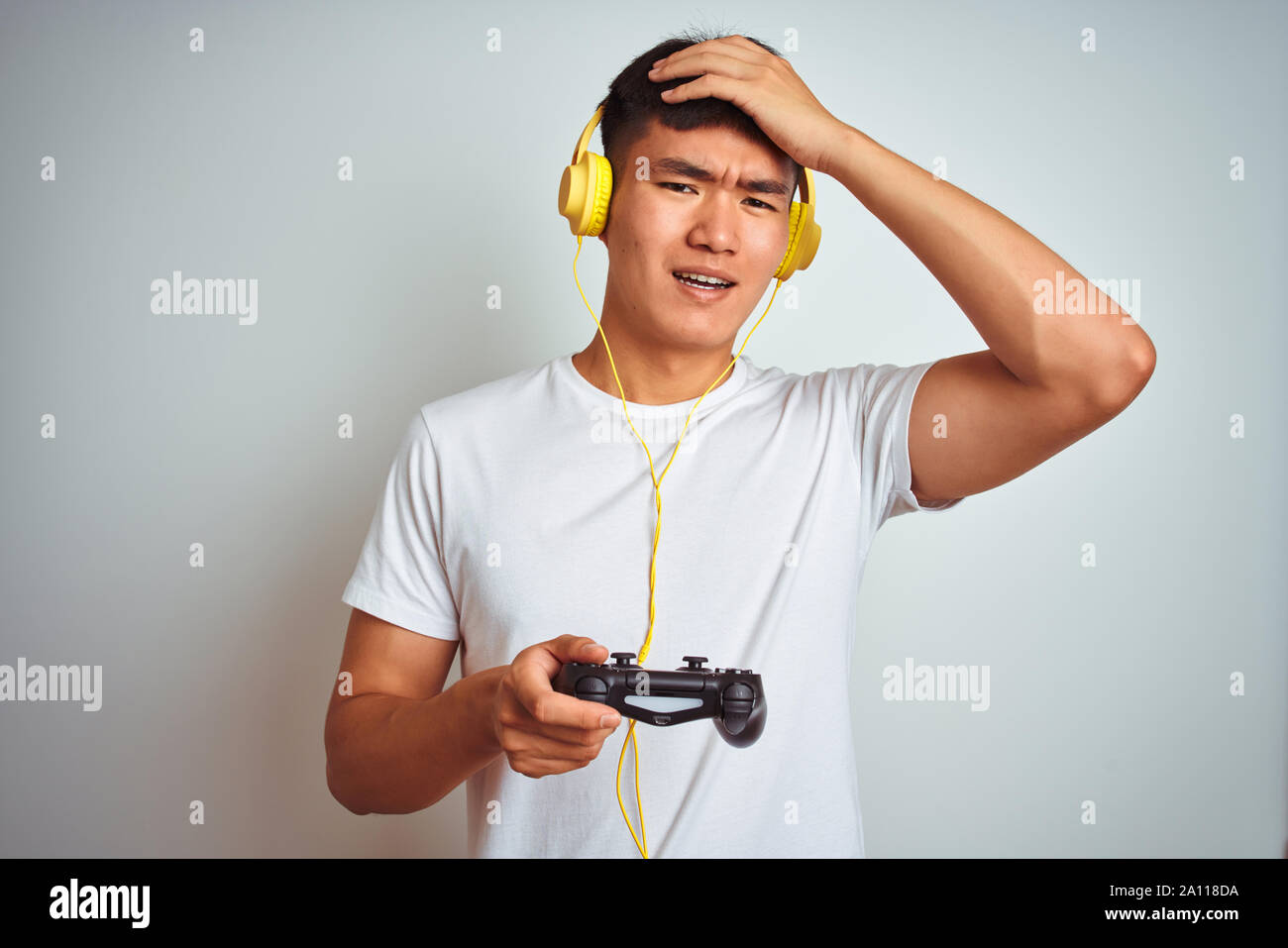 Young asian chinese gamer man playing video game standing over isolated ...