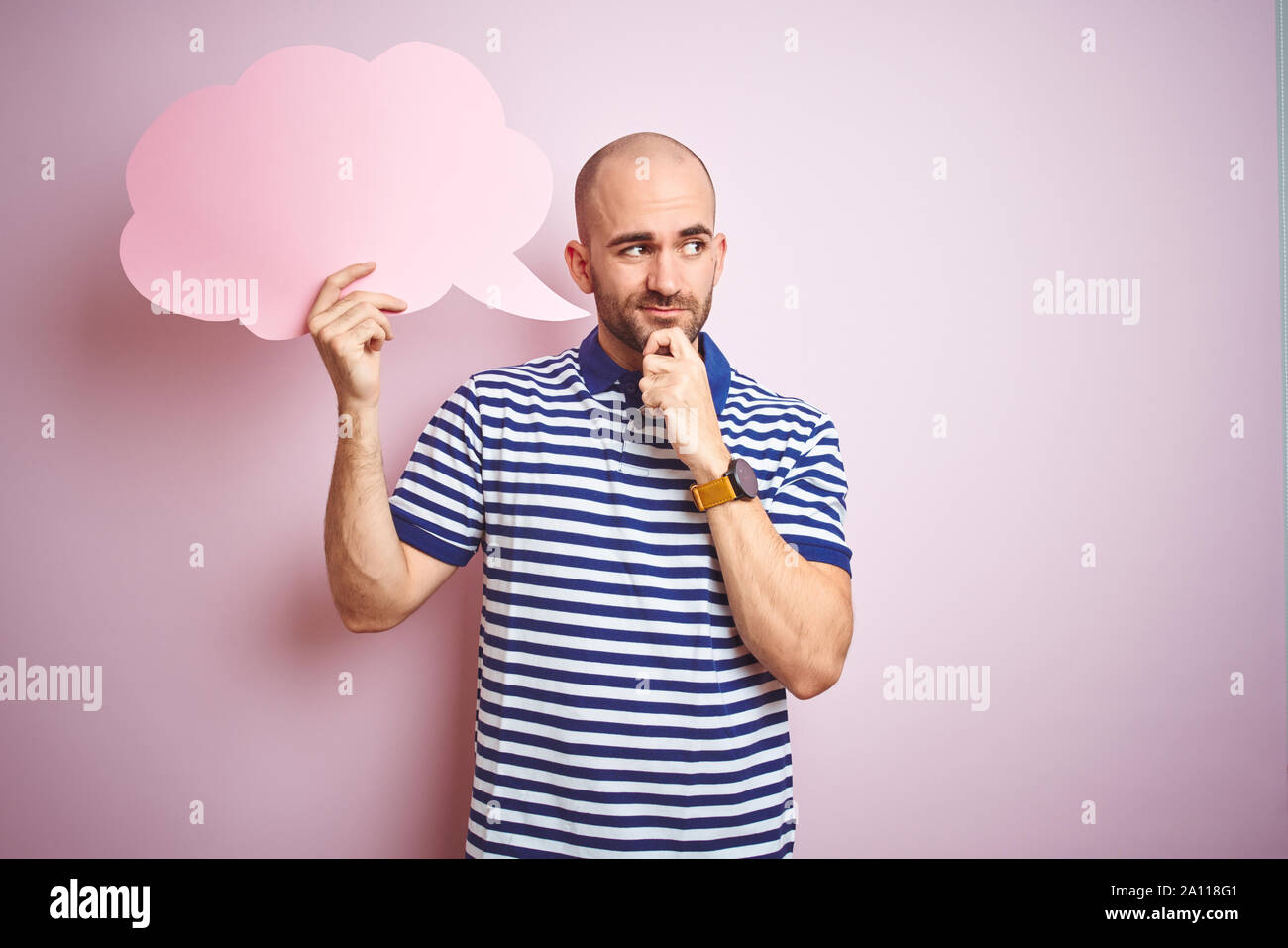 Young man holding speech bubble with blank space for message over pink ...