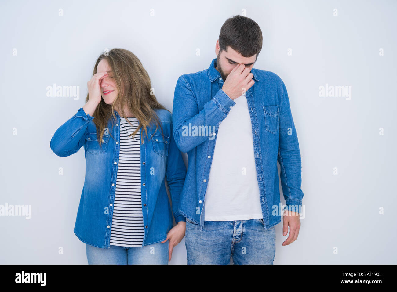 Young beautiful couple standing together over white isolated background ...