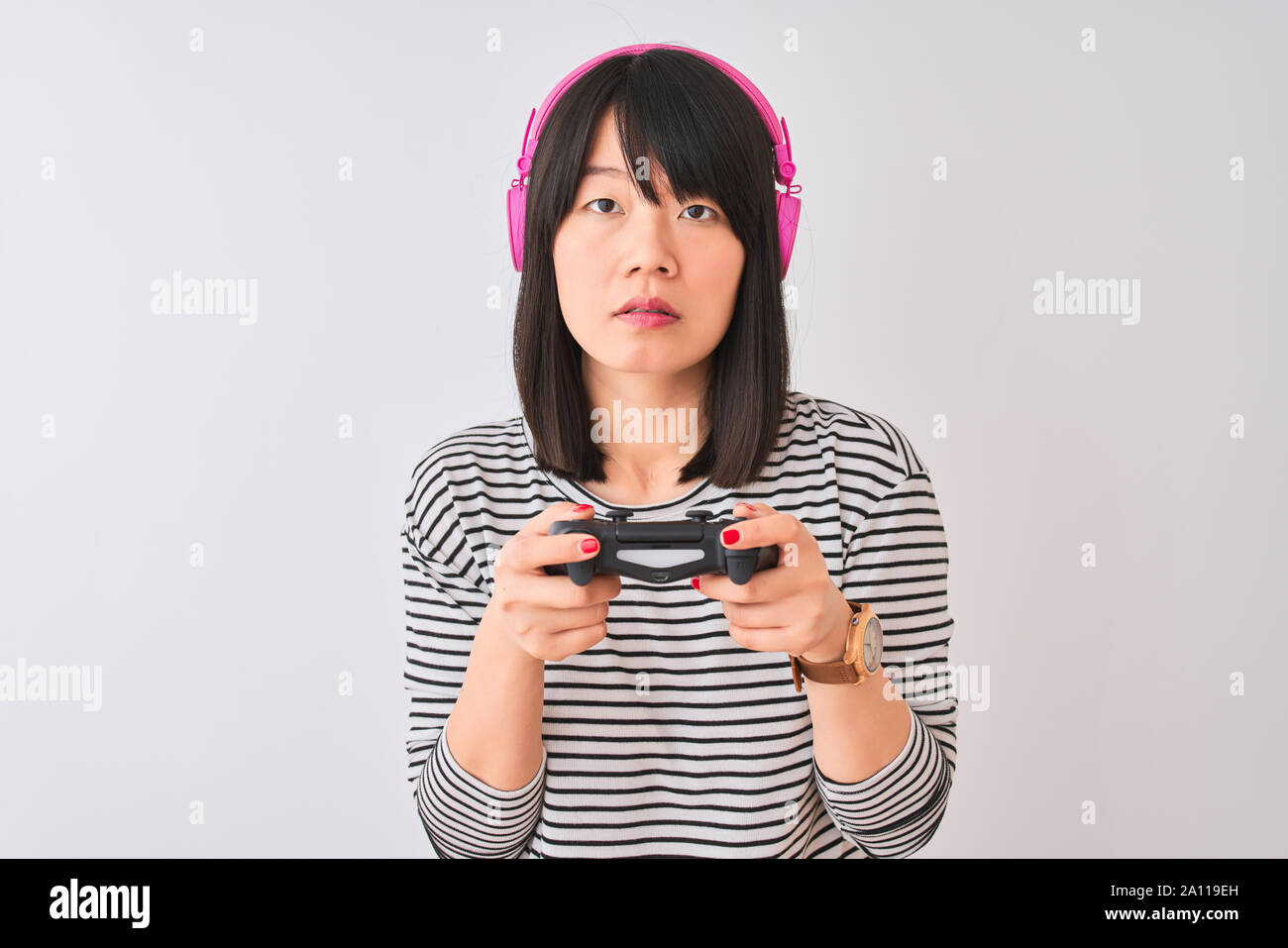 Chinese gamer woman playing video game using headphones over isolated ...