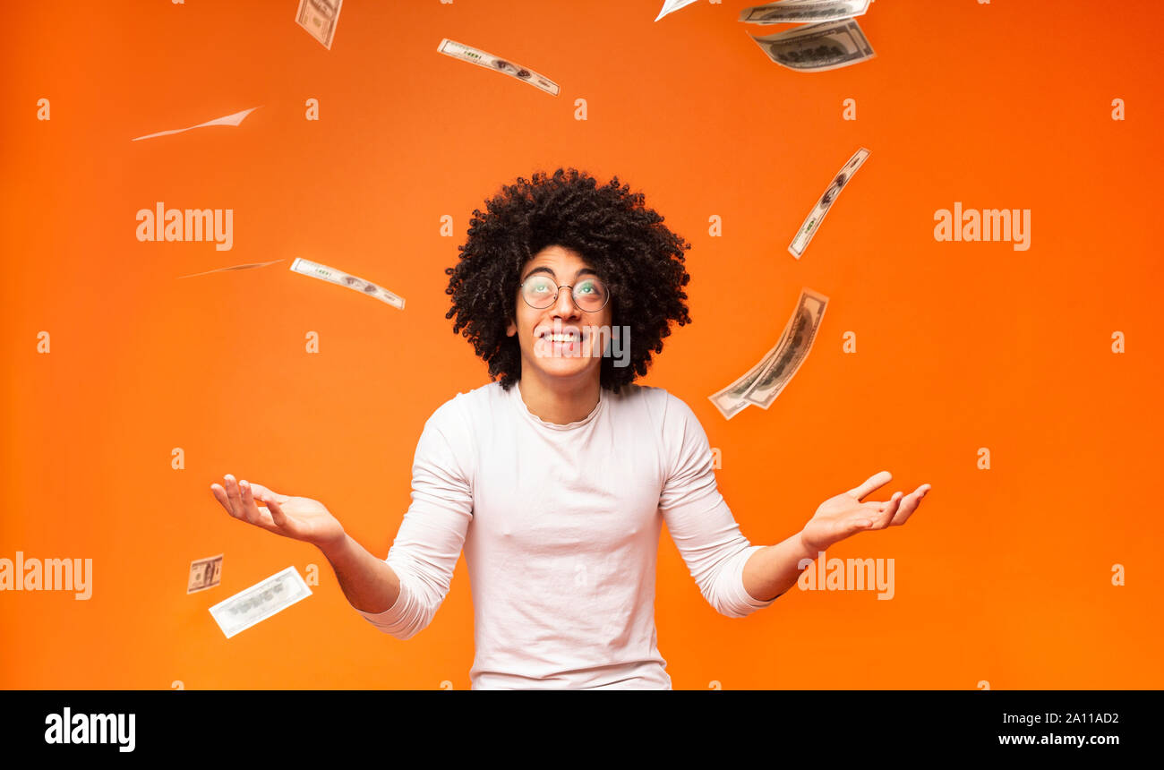 Excited black millennial guy enjoying rain of money Stock Photo - Alamy
