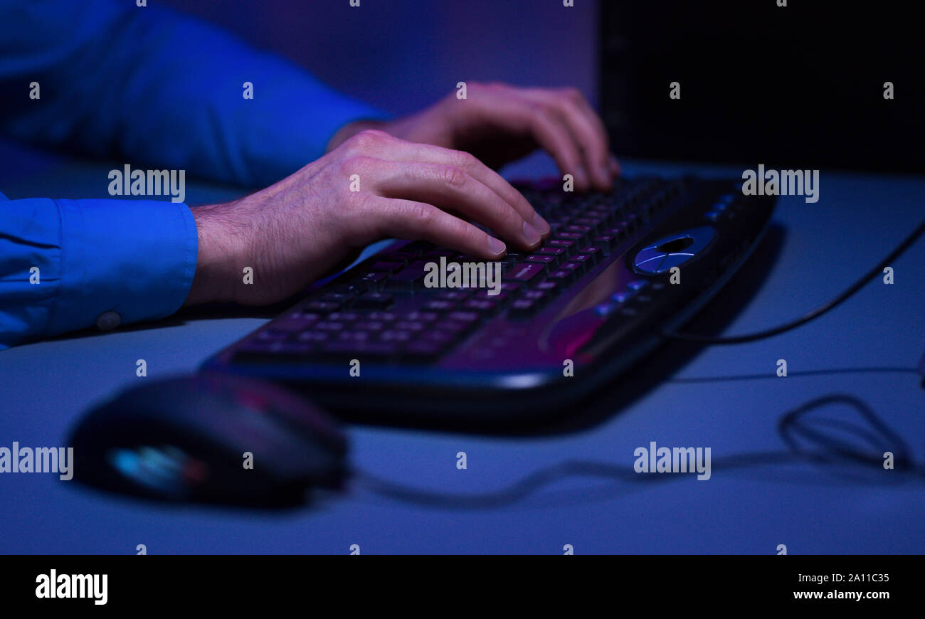 Gamer actively pushing buttons on keyboard, playing games Stock Photo ...