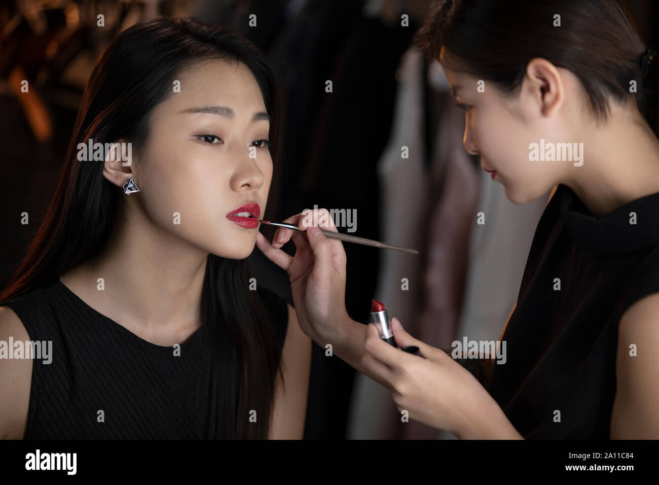 Makeup artist applying makeup on model Stock Photo - Alamy