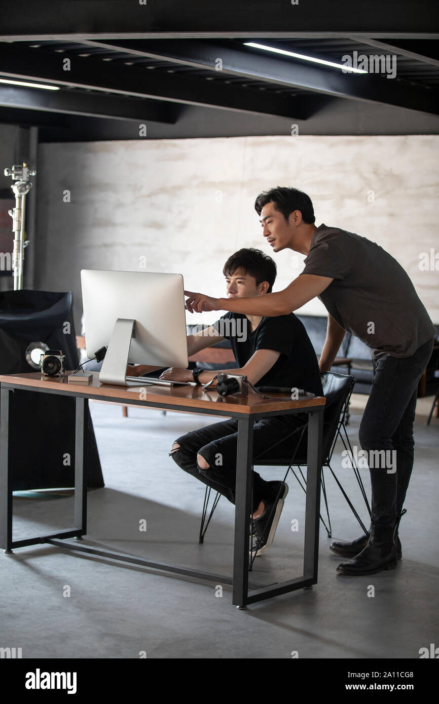 Photographers working in studio Stock Photo - Alamy