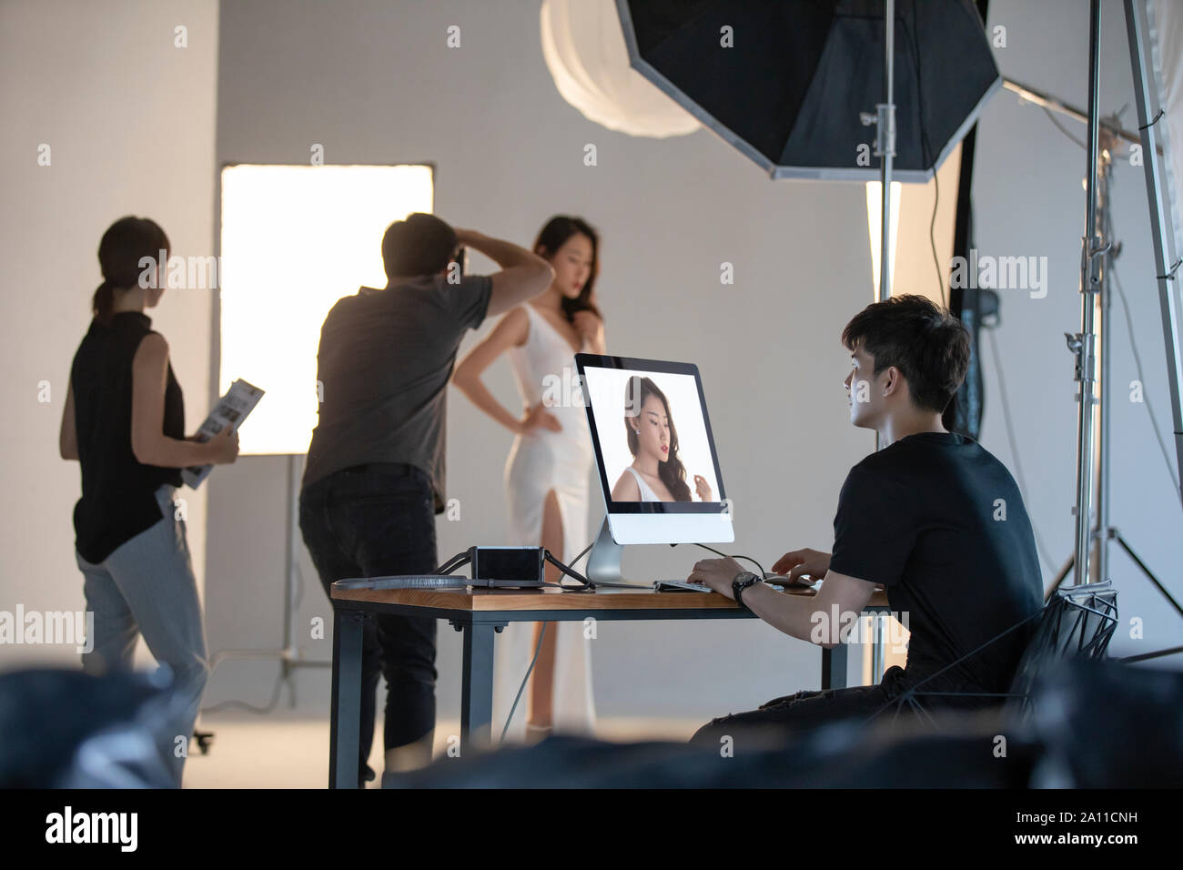 Photographer taking picture of model in studio Stock Photo - Alamy