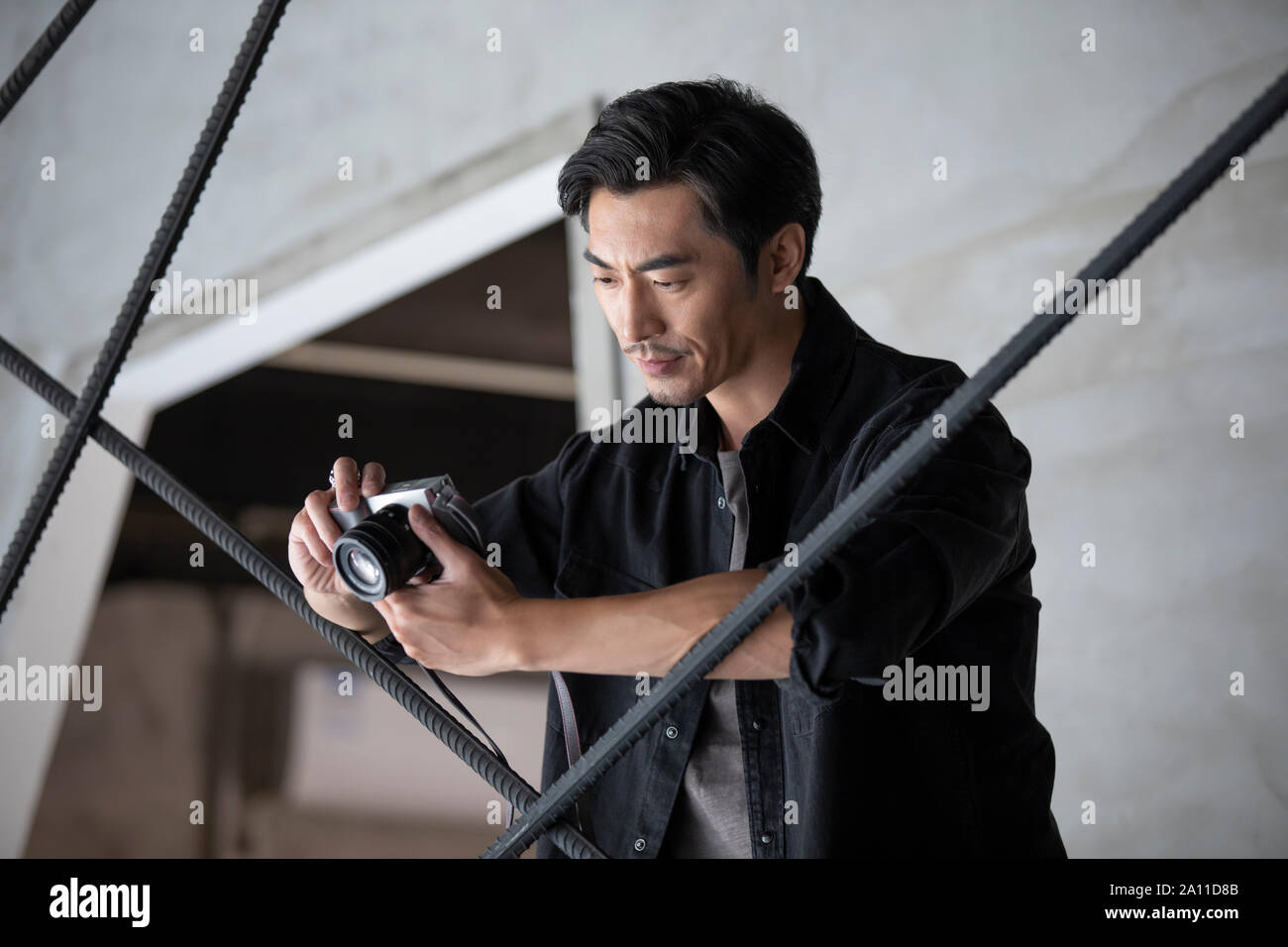 Photographer using camera in studio Stock Photo - Alamy