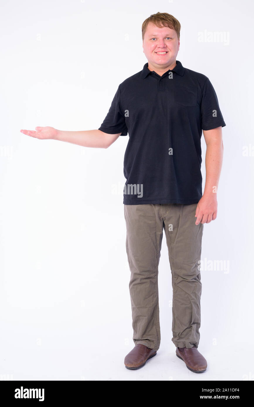 Full body shot of happy overweight man showing something Stock Photo ...