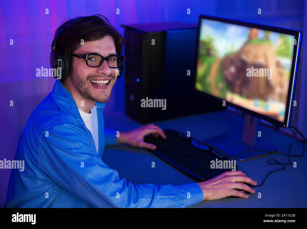 Happy guy playing video games on computer wearing headphones Stock ...