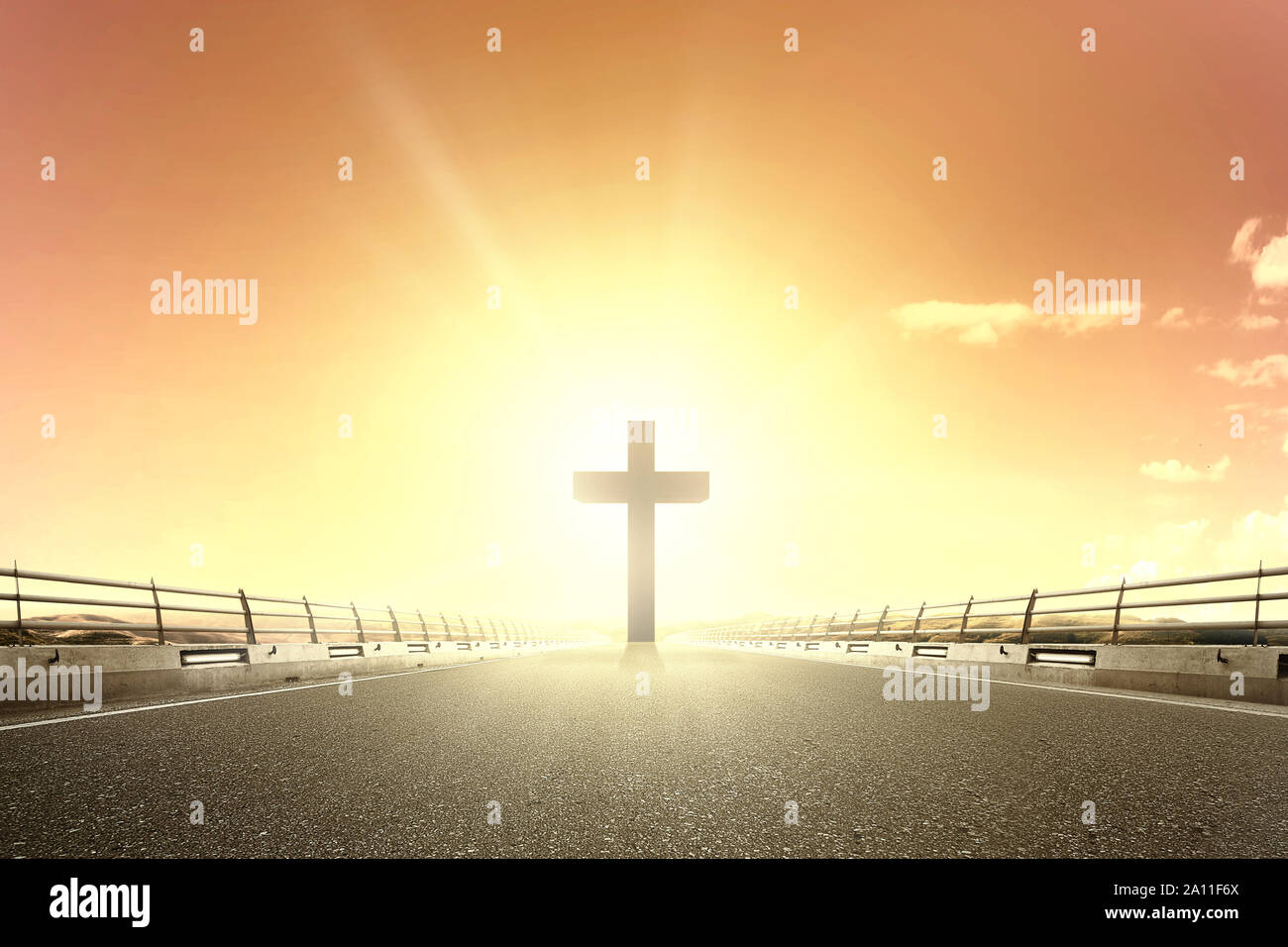 Christian cross at the end of the asphalt road with a sunset sky ...