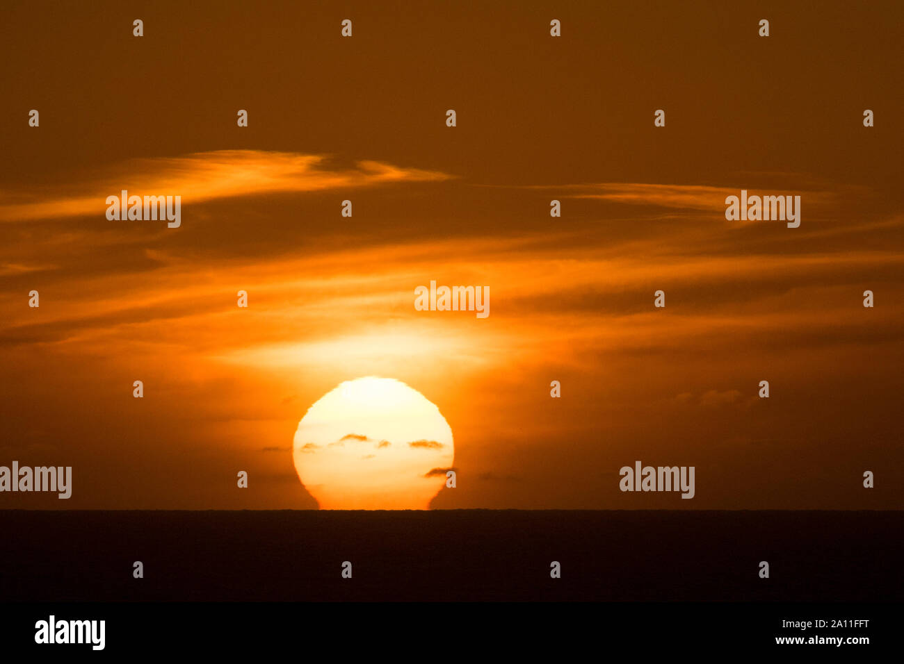 The sun begins dipping into the Pacific Ocean Stock Photo - Alamy