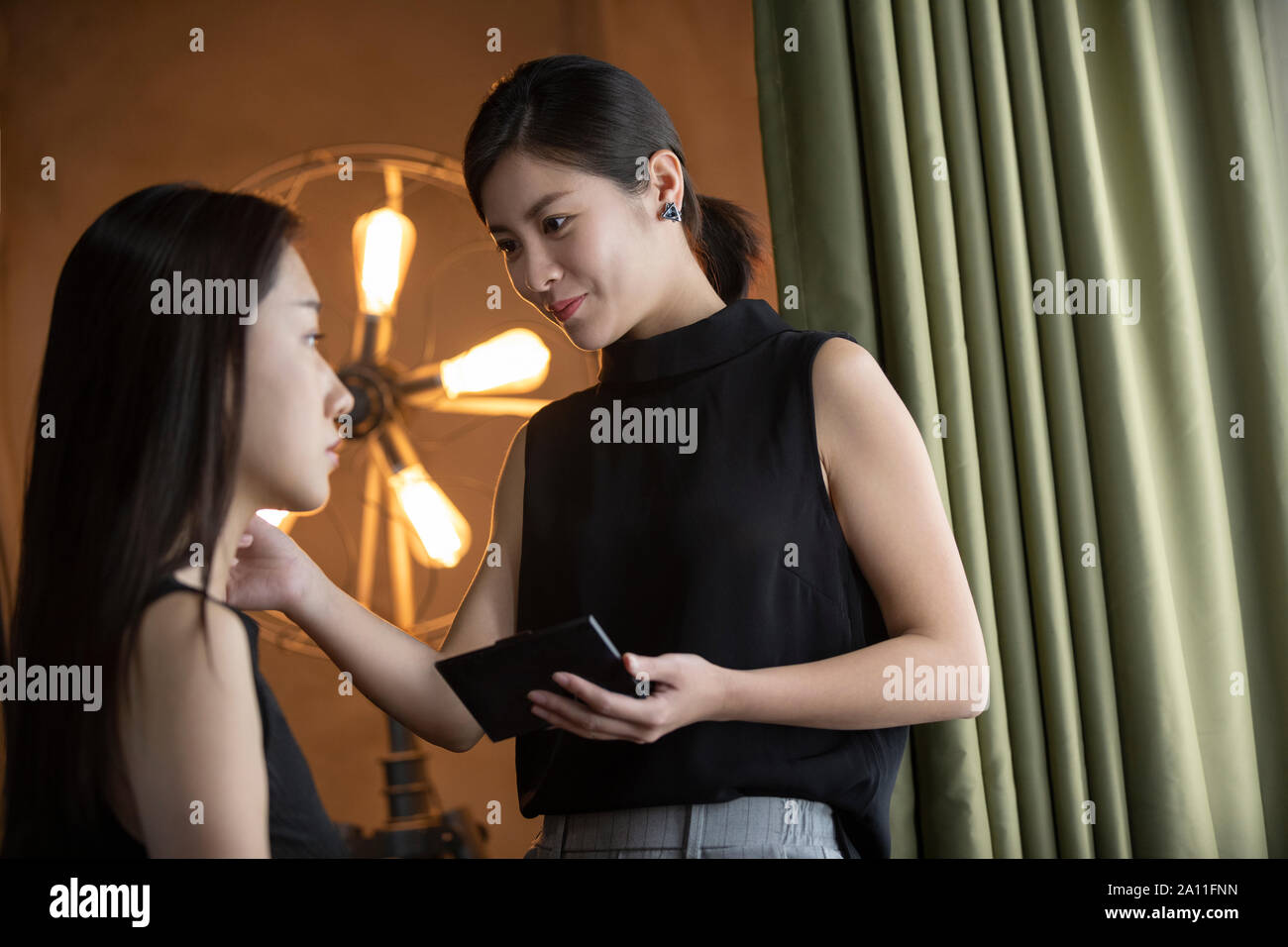 Makeup artist applying makeup on model Stock Photo - Alamy