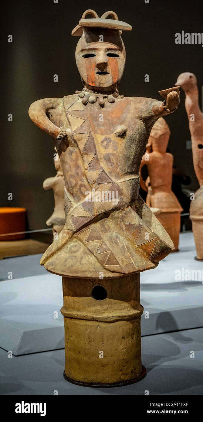 Haniwa (terracotta tomb figurine) woman with a painted face offering a ...