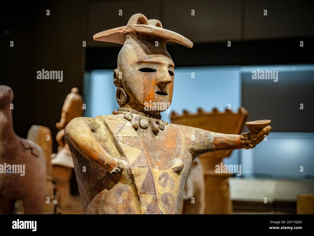 Haniwa (terracotta tomb figurine) woman with a painted face offering a ...