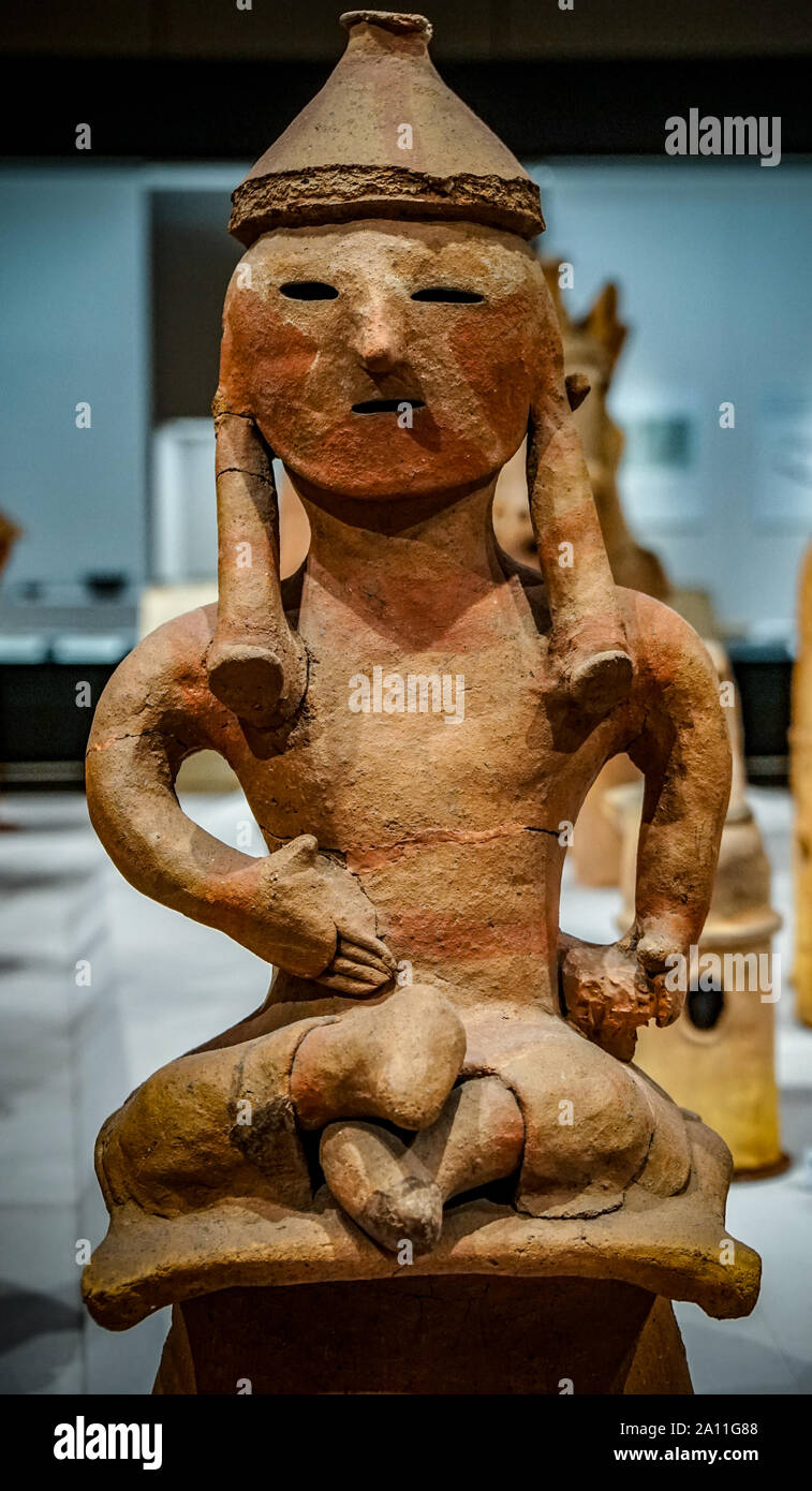 Haniwa (terracotta tomb figurine) man with painted face sitting cross ...