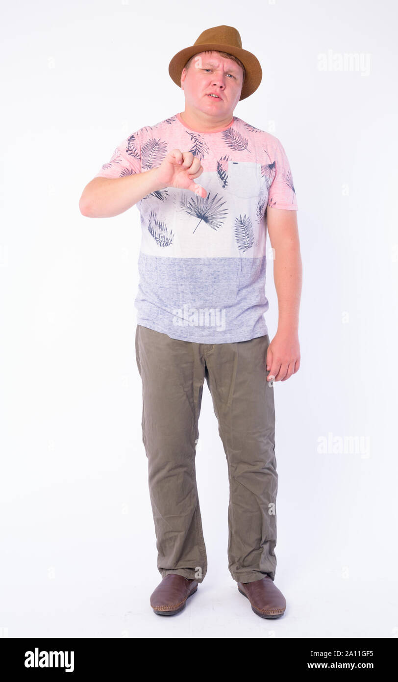 Full body shot of stressed overweight tourist man giving thumbs down ...