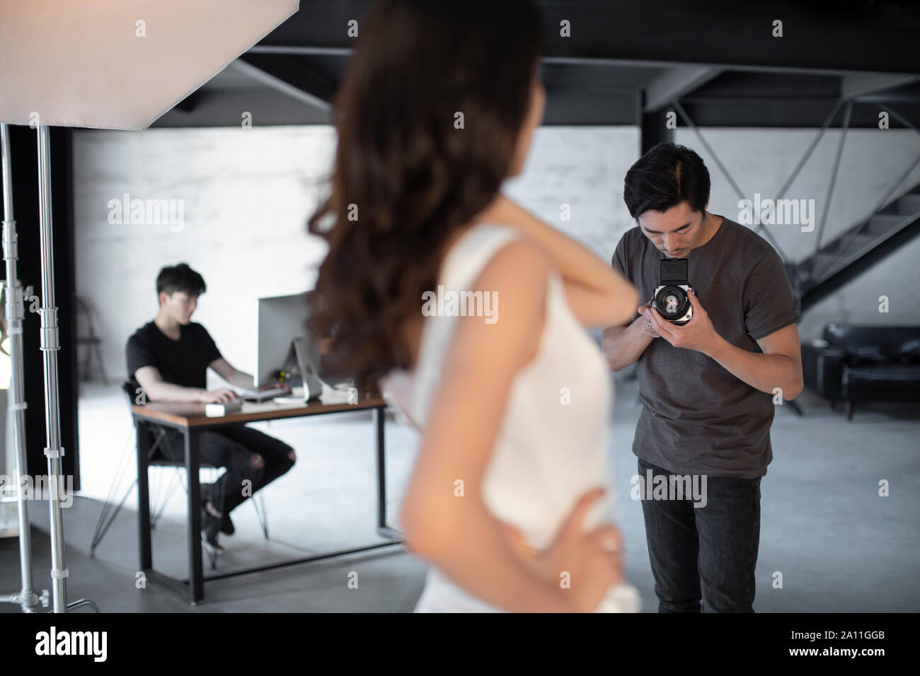 Photographer taking picture of model in studio Stock Photo - Alamy