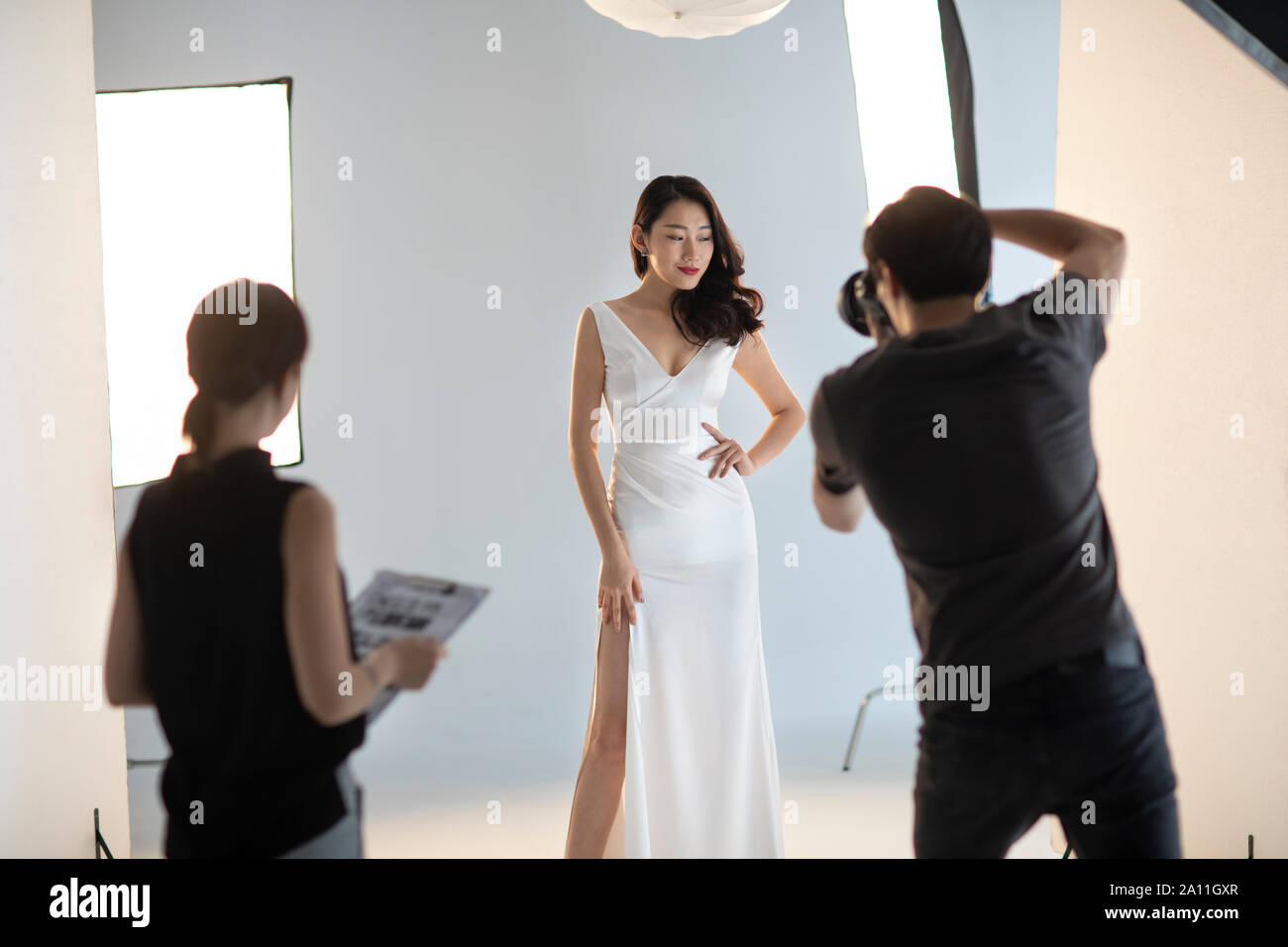 Photographer taking picture of model in studio Stock Photo - Alamy