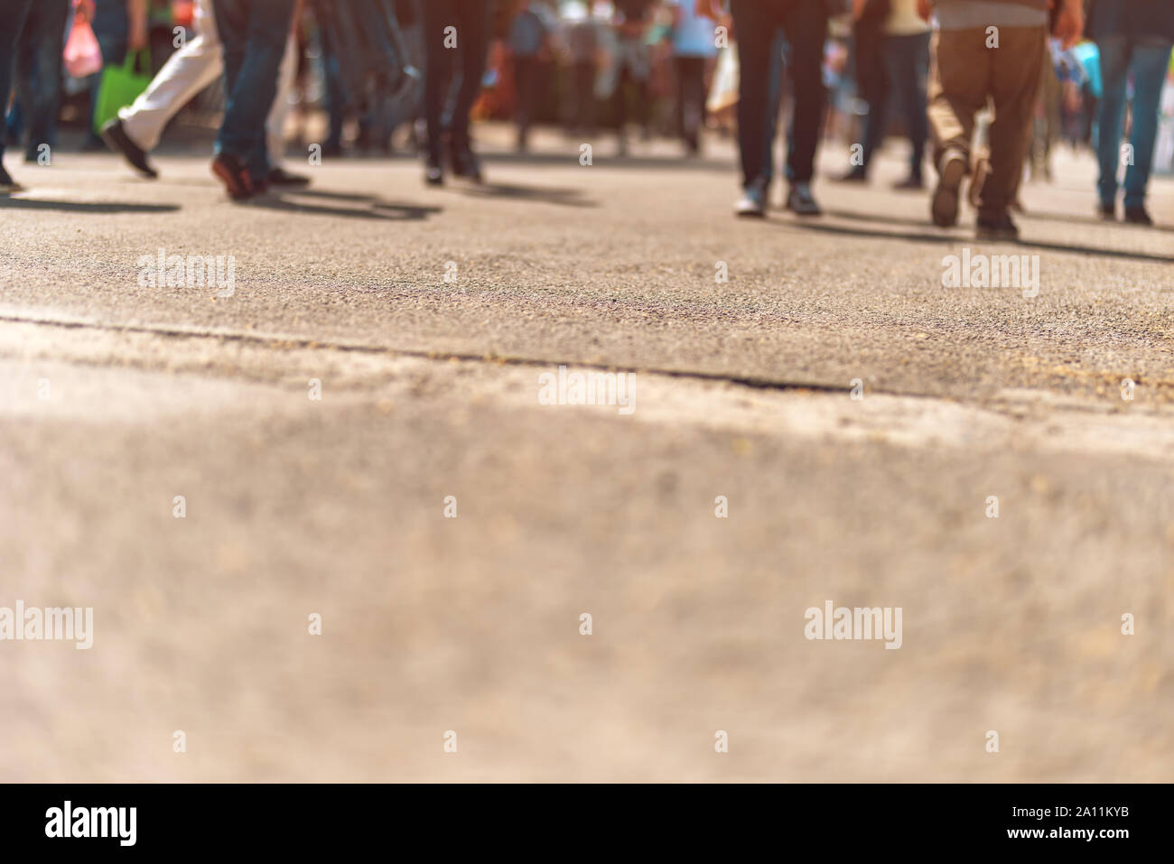 Crowded street and people walking, low angle view on pedestrian legs ...