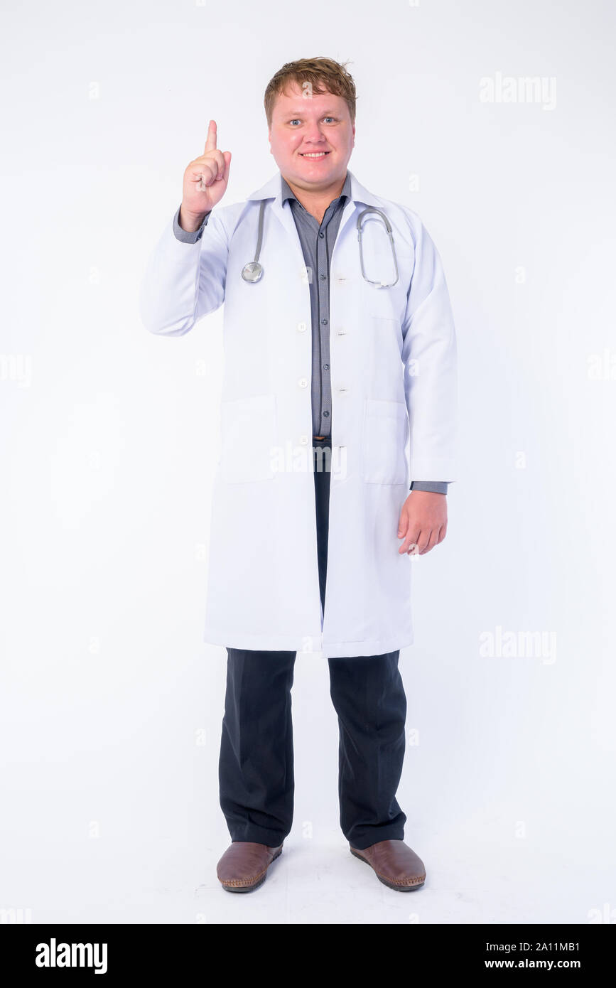 Full body shot of happy overweight man doctor pointing up Stock Photo ...