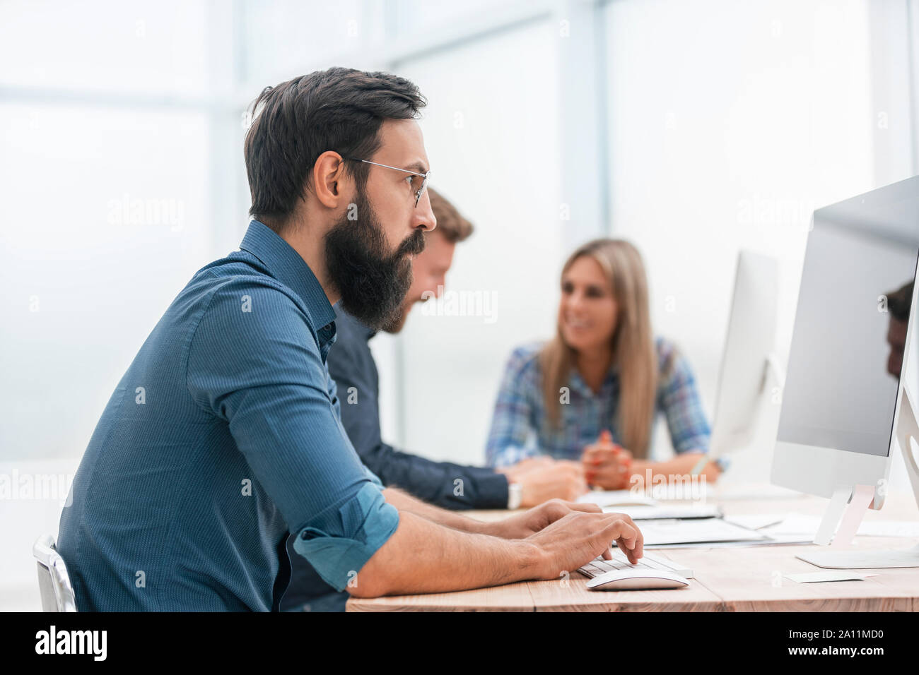 business team sitting at the Desk in the office Stock Photo - Alamy
