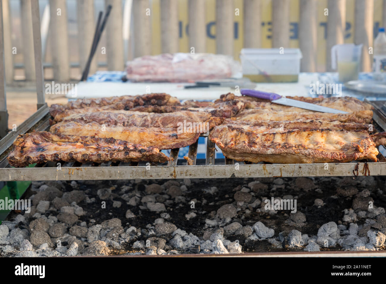 BBQ rack of pork ribs lined up on a large outdoor grill with smoke ...