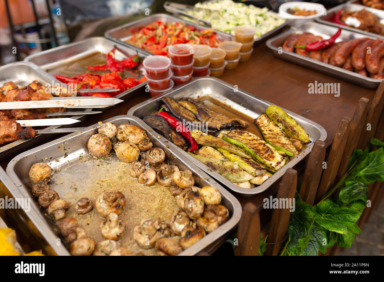 A counter with metal trays containing grilled food. Food and cooking ...