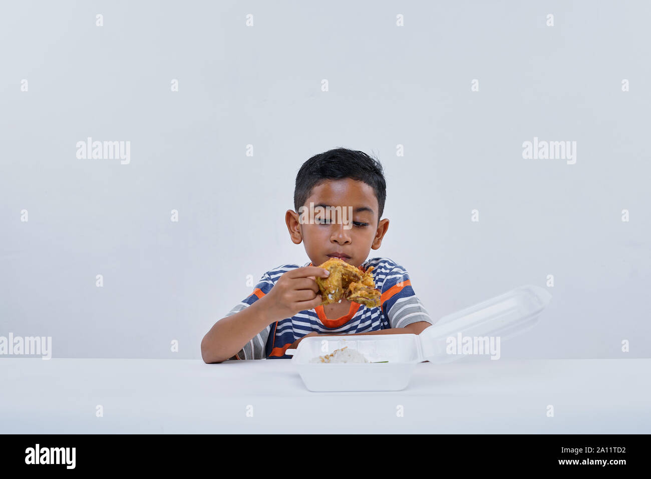 Schoolboy eating fried chicken fastfood on white background Stock Photo ...