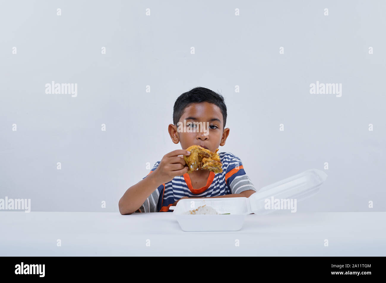 Schoolboy eating fried chicken fastfood on white background Stock Photo ...