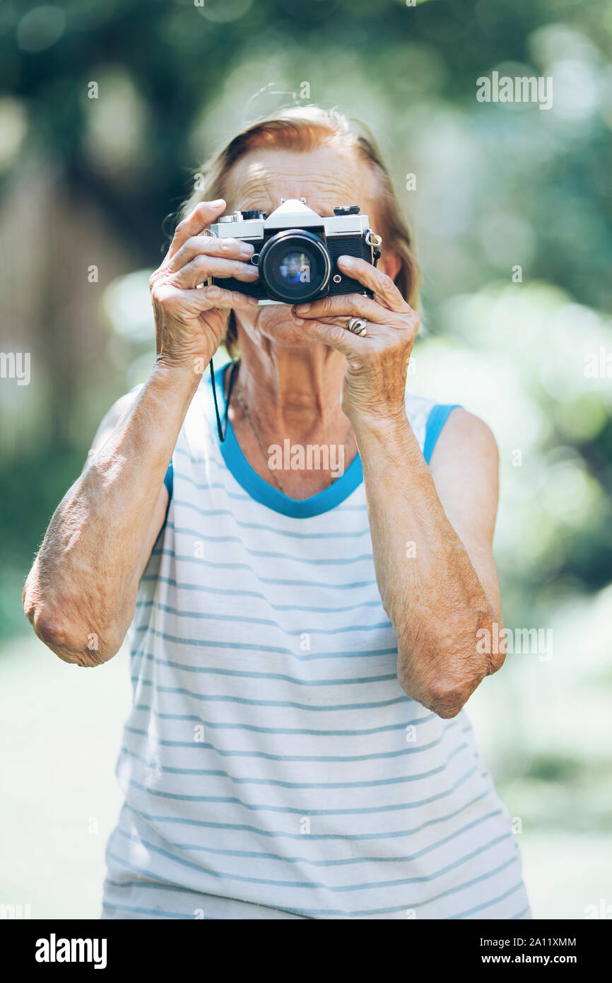 Elderly woman with a vintage film photo camera Stock Photo - Alamy