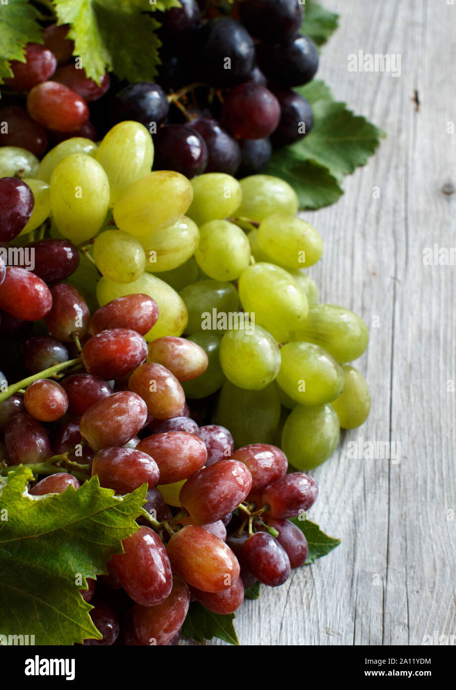 Three types of grapes on a wooden Background Stock Photo - Alamy