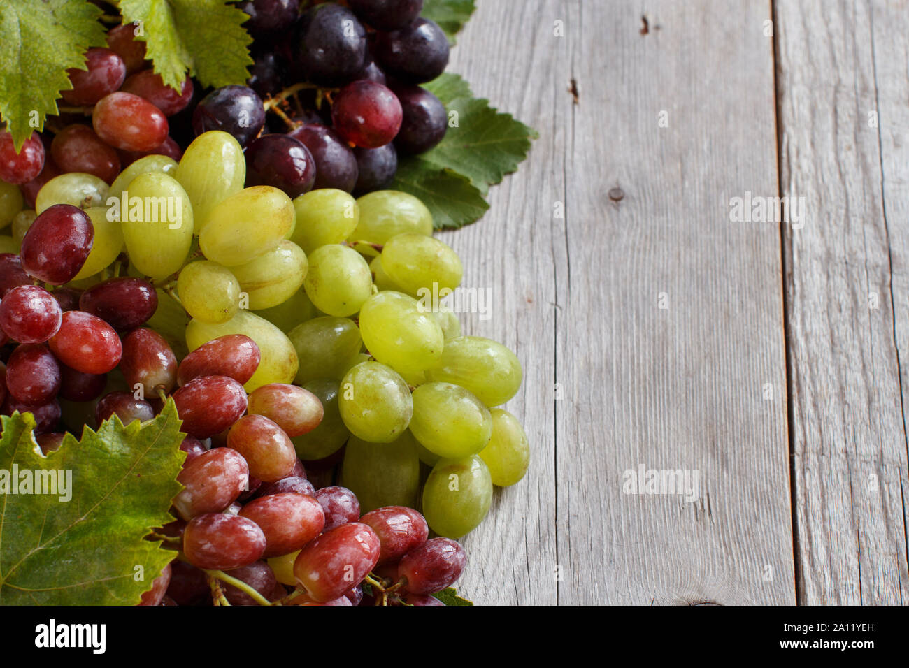 Three types of grapes on a wooden Background Stock Photo - Alamy