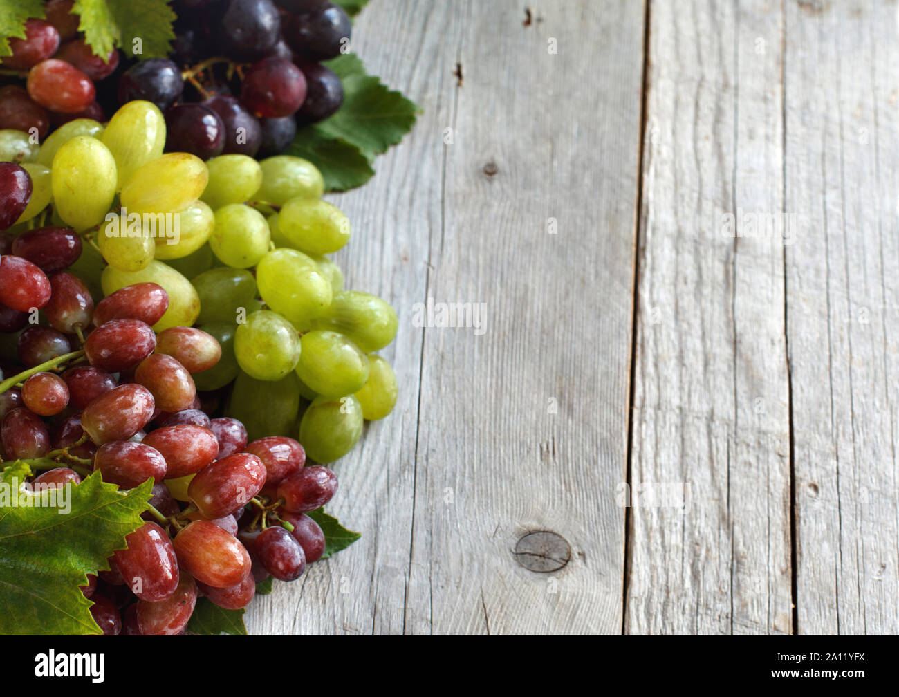 Three types of grapes on a wooden Background Stock Photo - Alamy