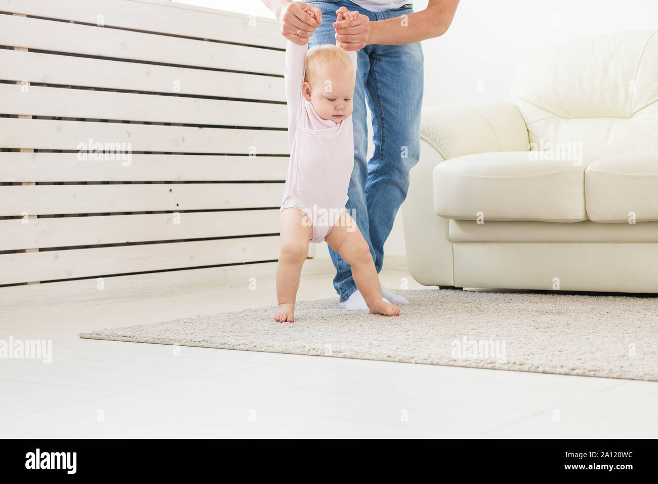 Little baby girl first steps with the help of father Stock Photo - Alamy