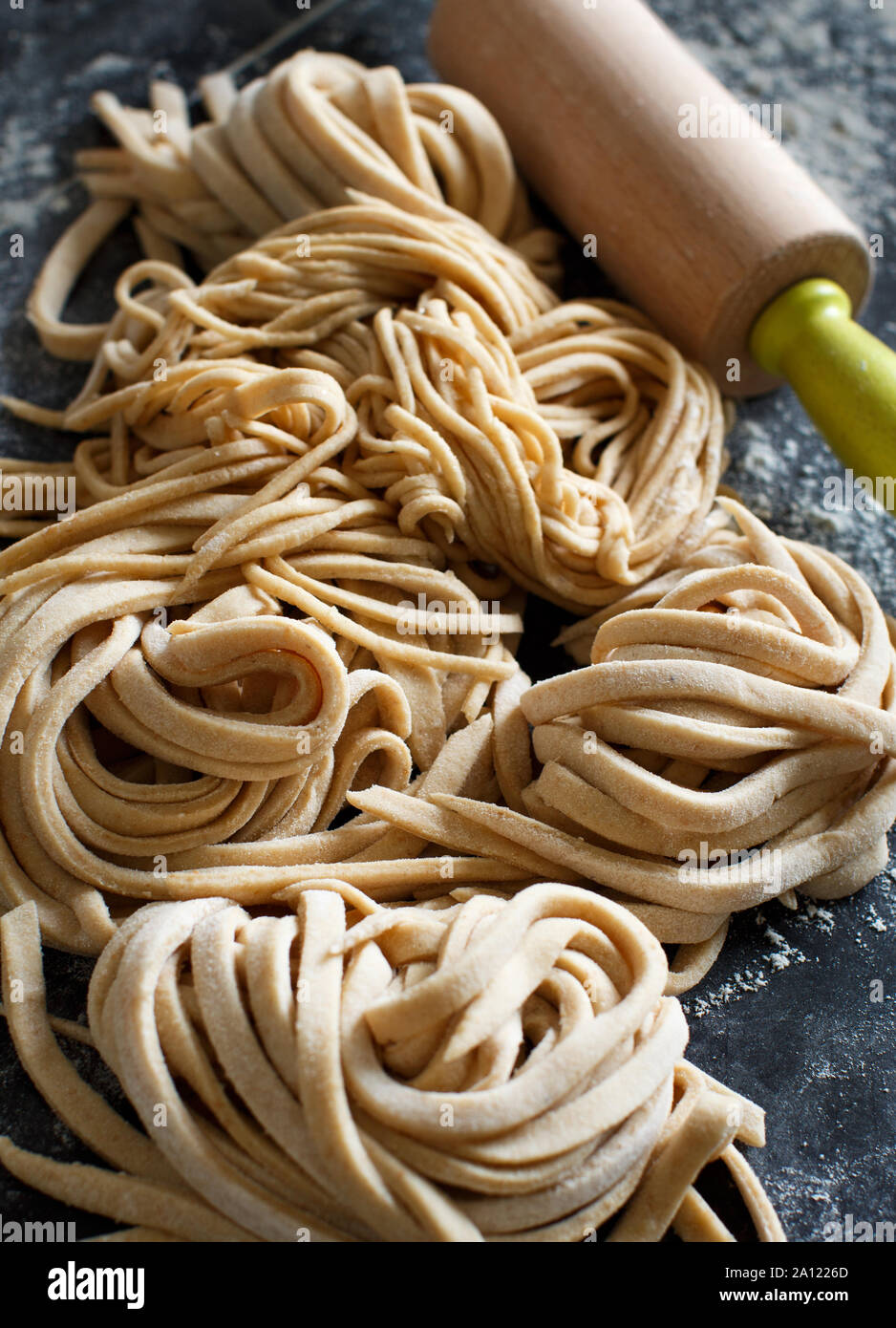Fresh homemade pasta and rolling pin on a dark background Stock Photo ...