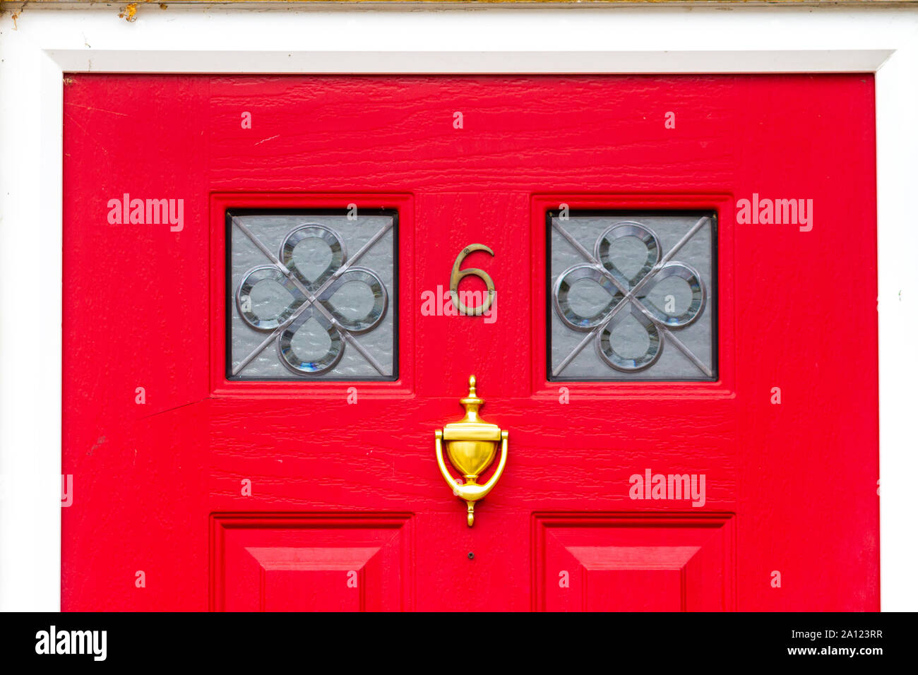 House number 6 on a bright red wooden front door with glass panels and ...