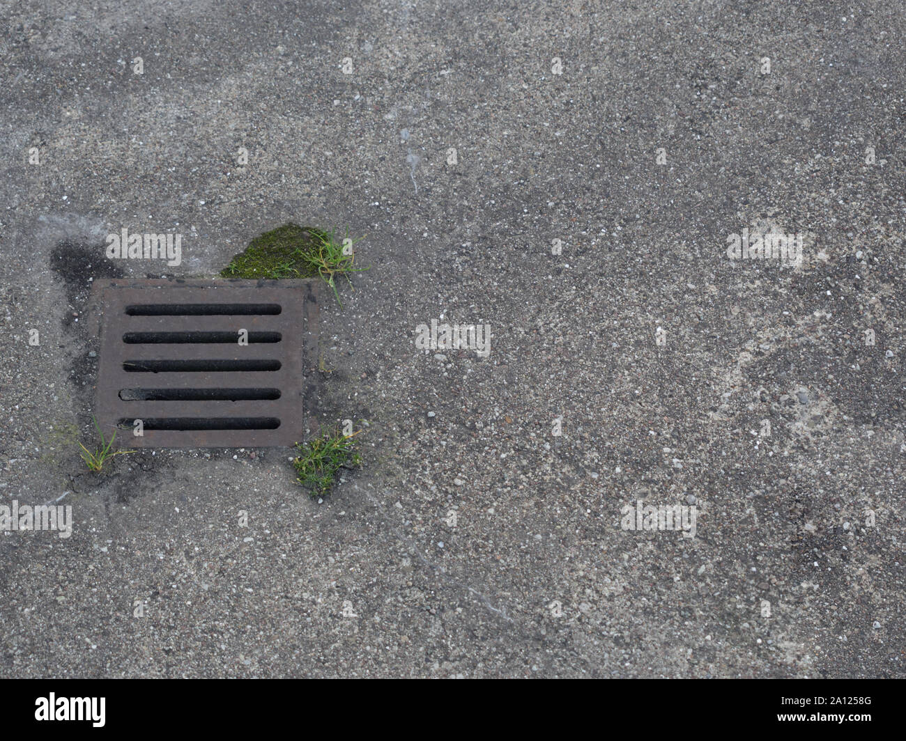 Rusty drain on grainy ground Stock Photo - Alamy