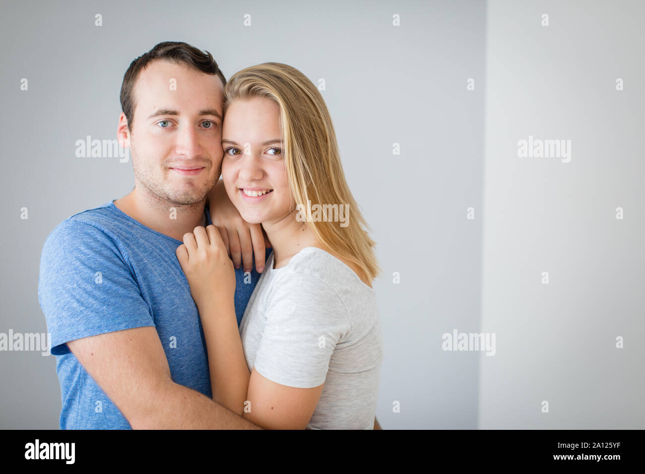 Brother and sister posing for a photo together. Hugging and smiling ...