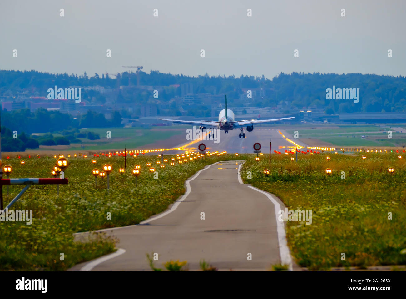 Airplane landing at airport runway, back view Stock Photo - Alamy