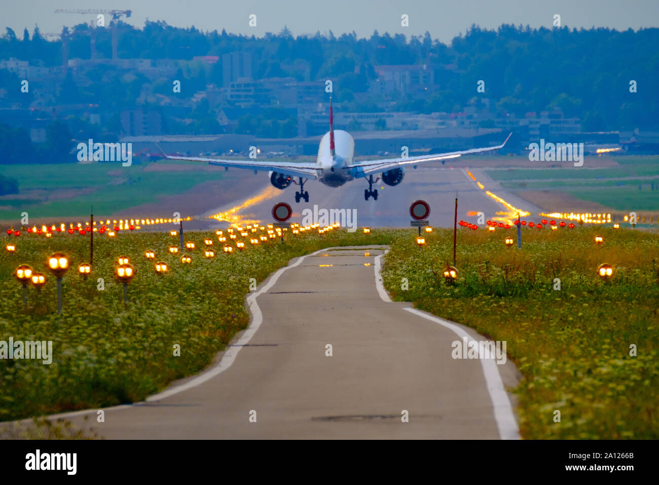 Airplane landing at airport runway, back view Stock Photo - Alamy