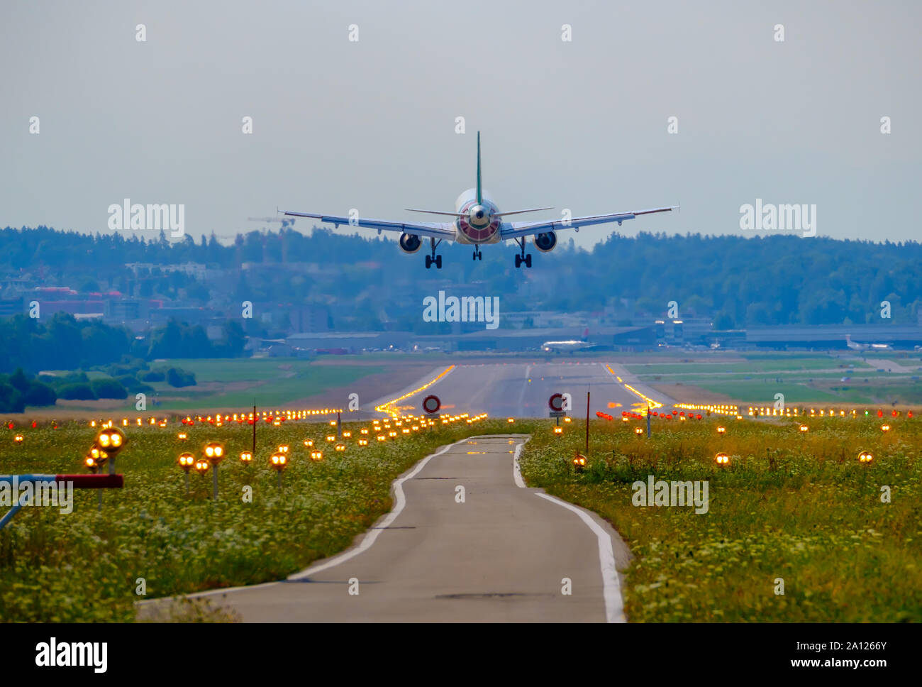 Airplane landing at airport runway, back view Stock Photo - Alamy