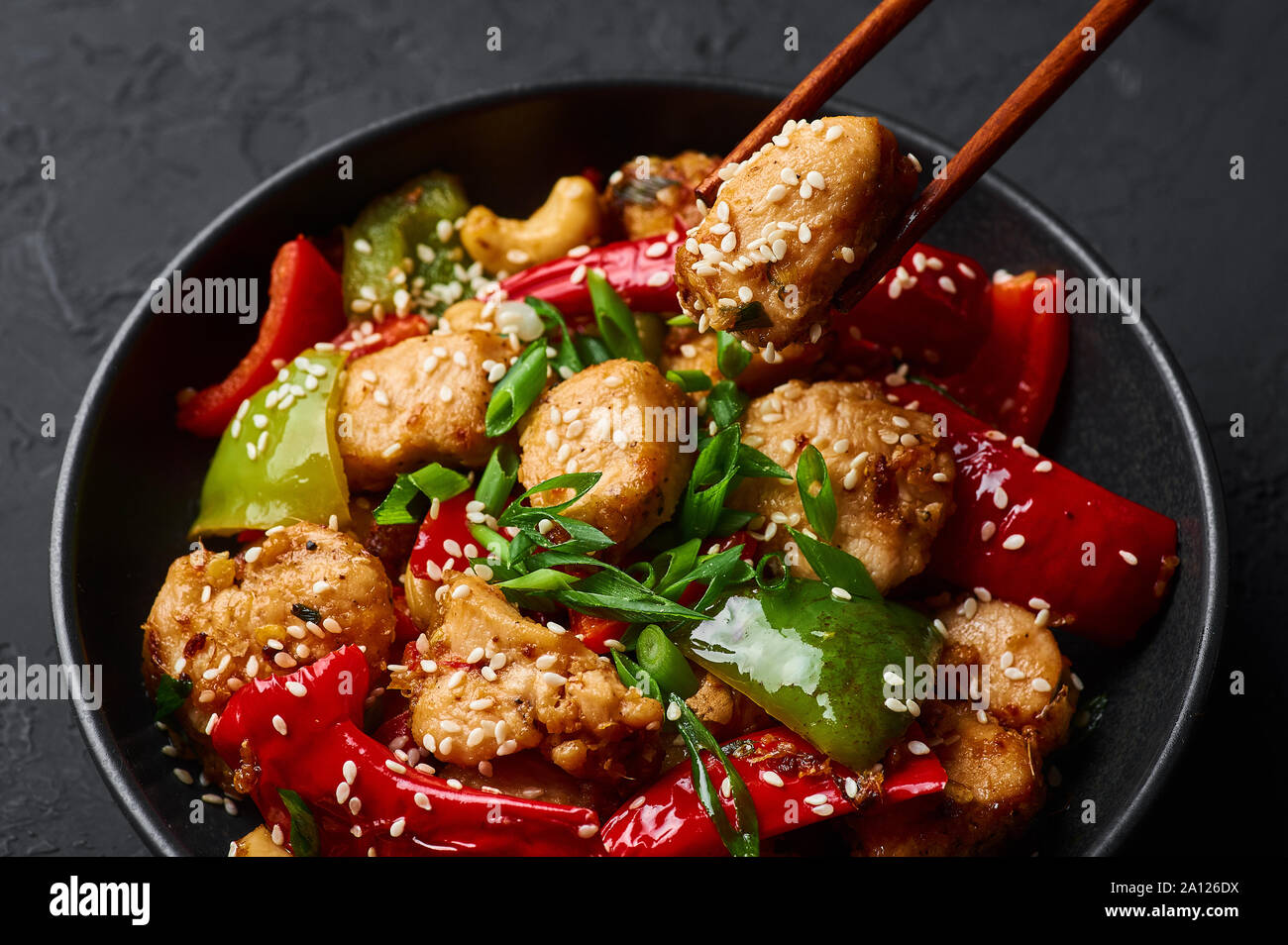 Schezwan Chicken or Dragon Chicken in black bowl at dark slate ...