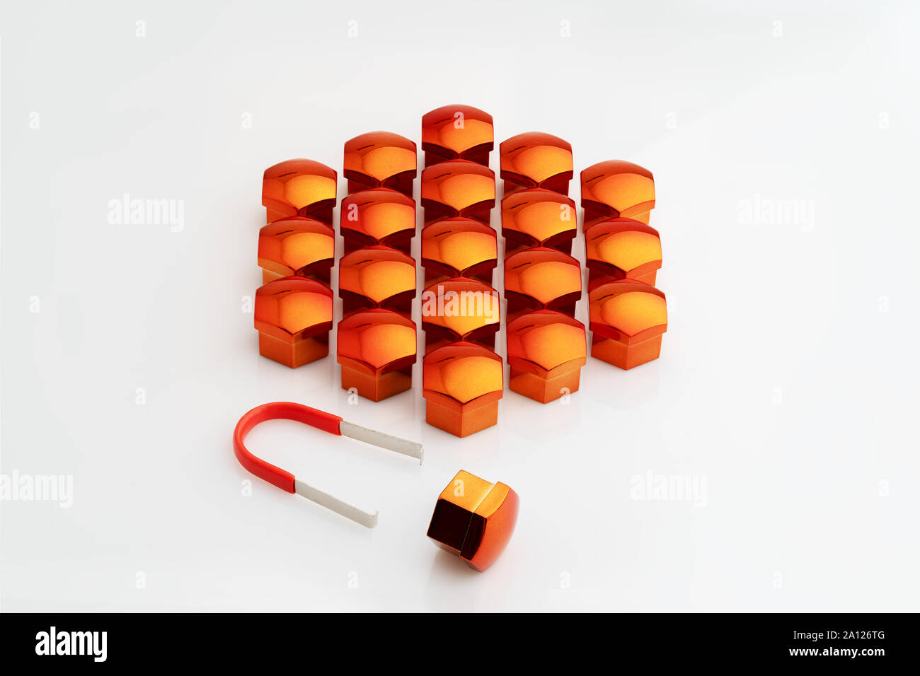 colored caps for automotive nuts or bolts, orange metallic . Close up ...