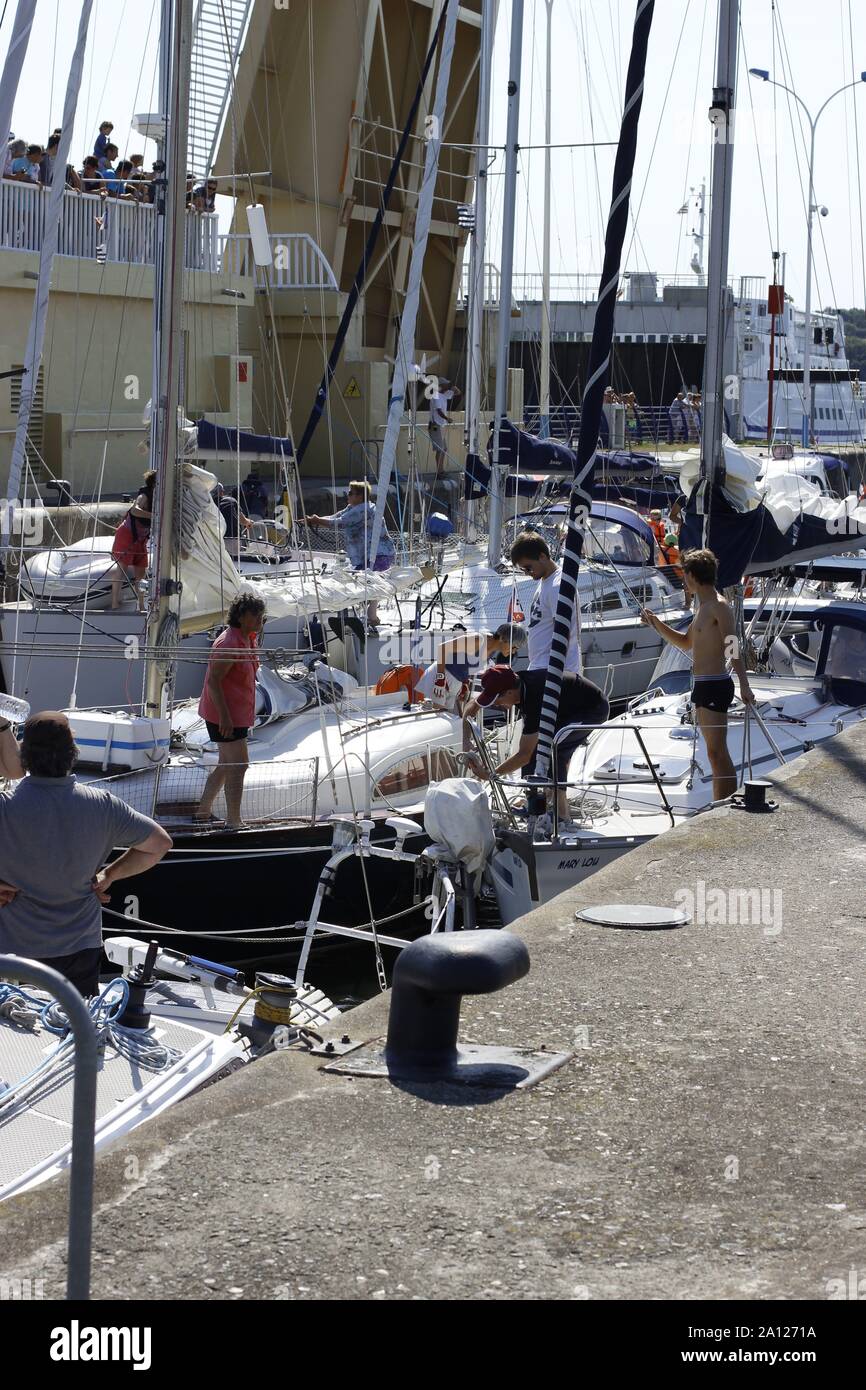 a busy scene showing a number of yachts grouped together in a lock ...