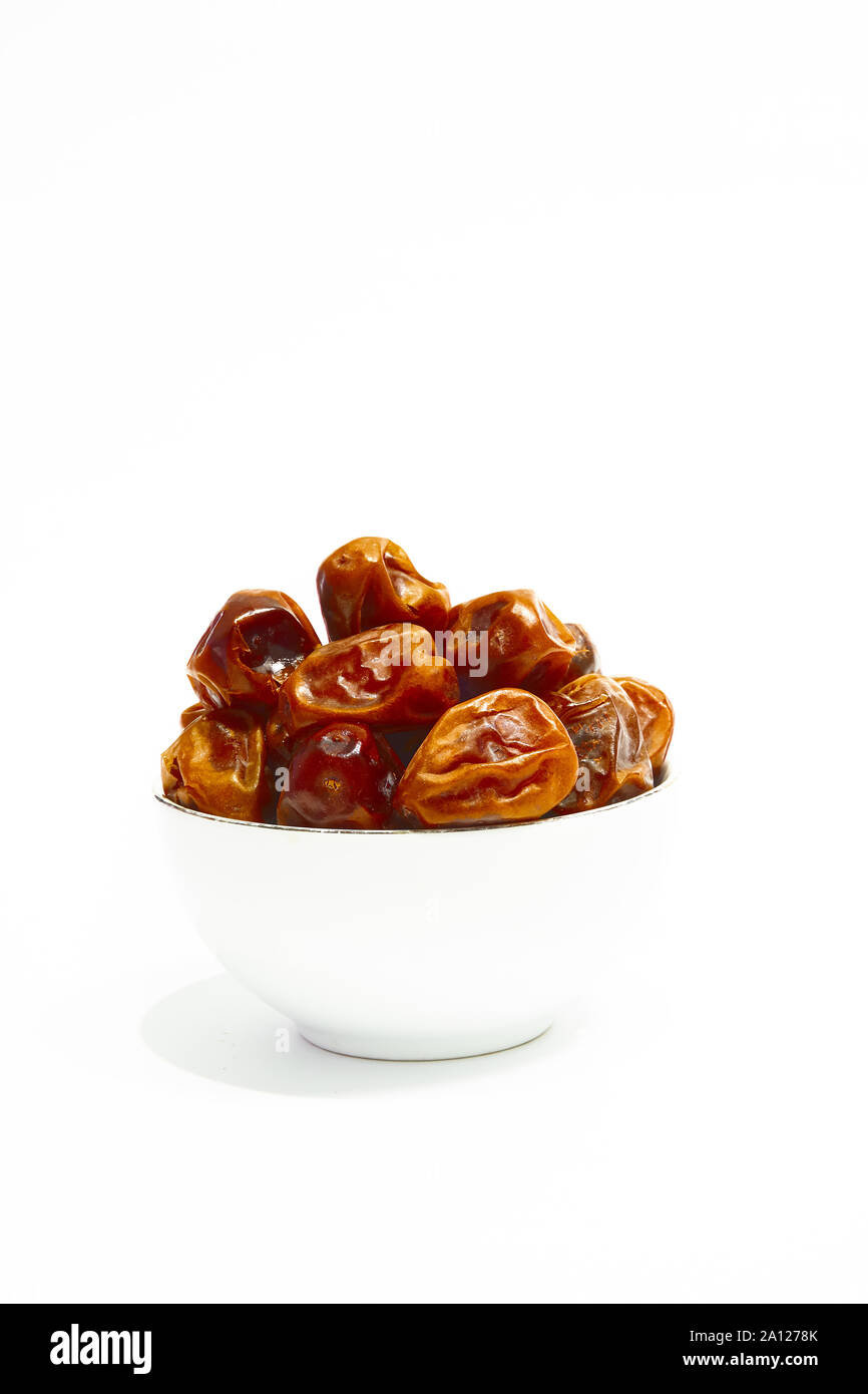 Bowl of dates isolated on white background Stock Photo - Alamy