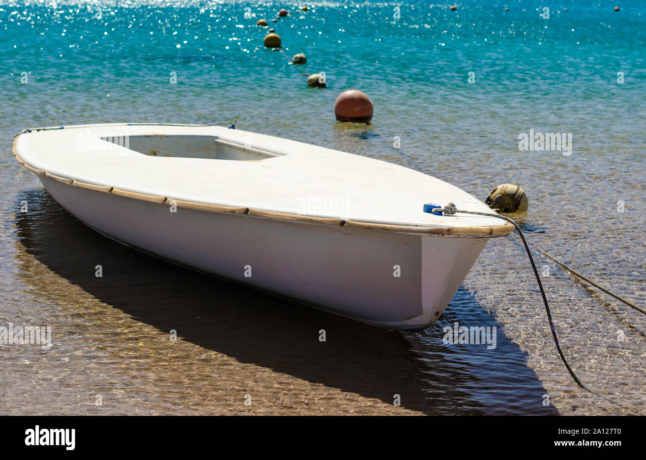 tethered boat in turquoise water with buoys Stock Photo - Alamy