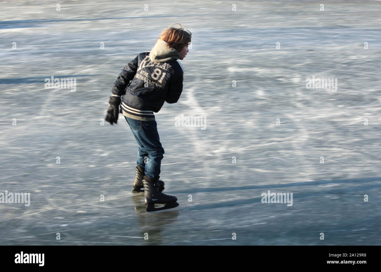Boy ice skating on natural ice Stock Photo - Alamy