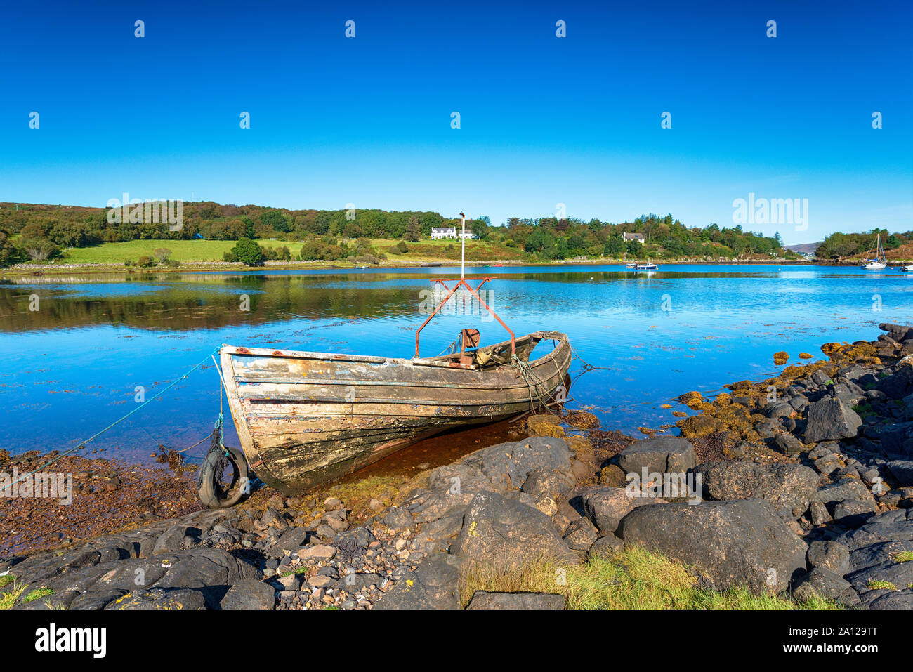 Deep blue sky over an old boat on the shore at Badachro near Gairloch ...