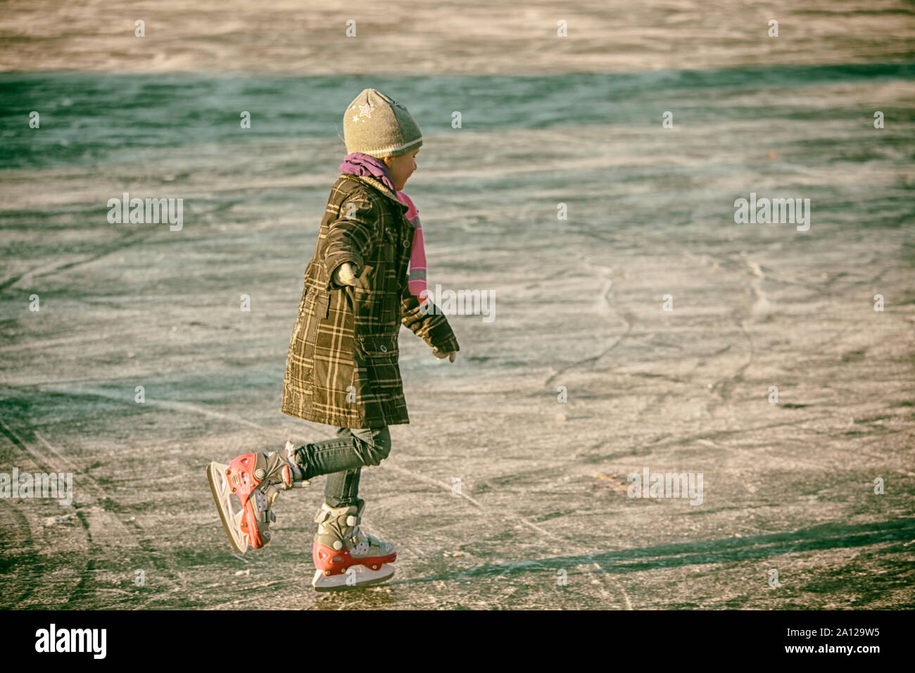 Small girl learning ice skating on natural ice Stock Photo - Alamy