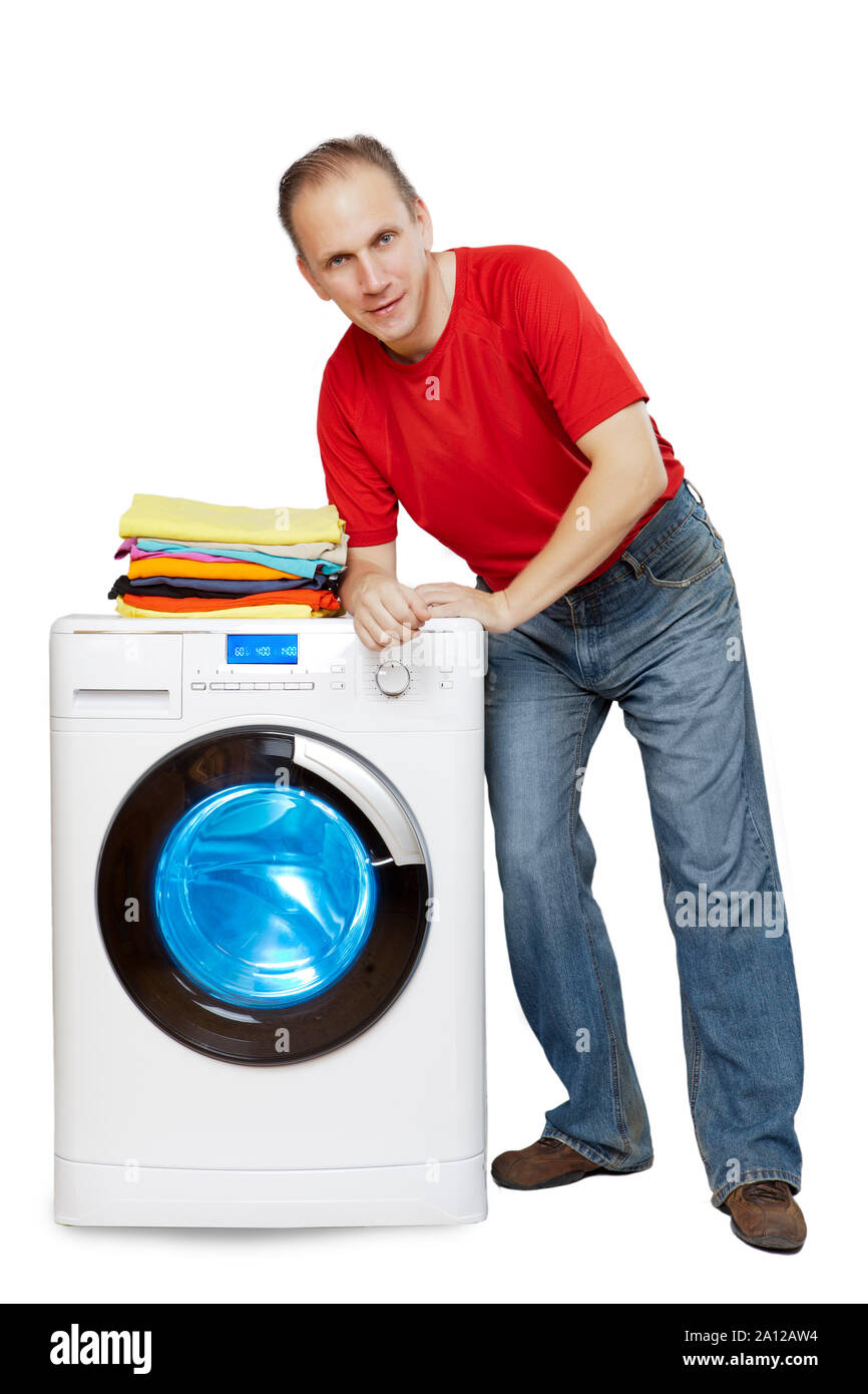 happy man smiling standing next to a new washing machine and a stack of ...