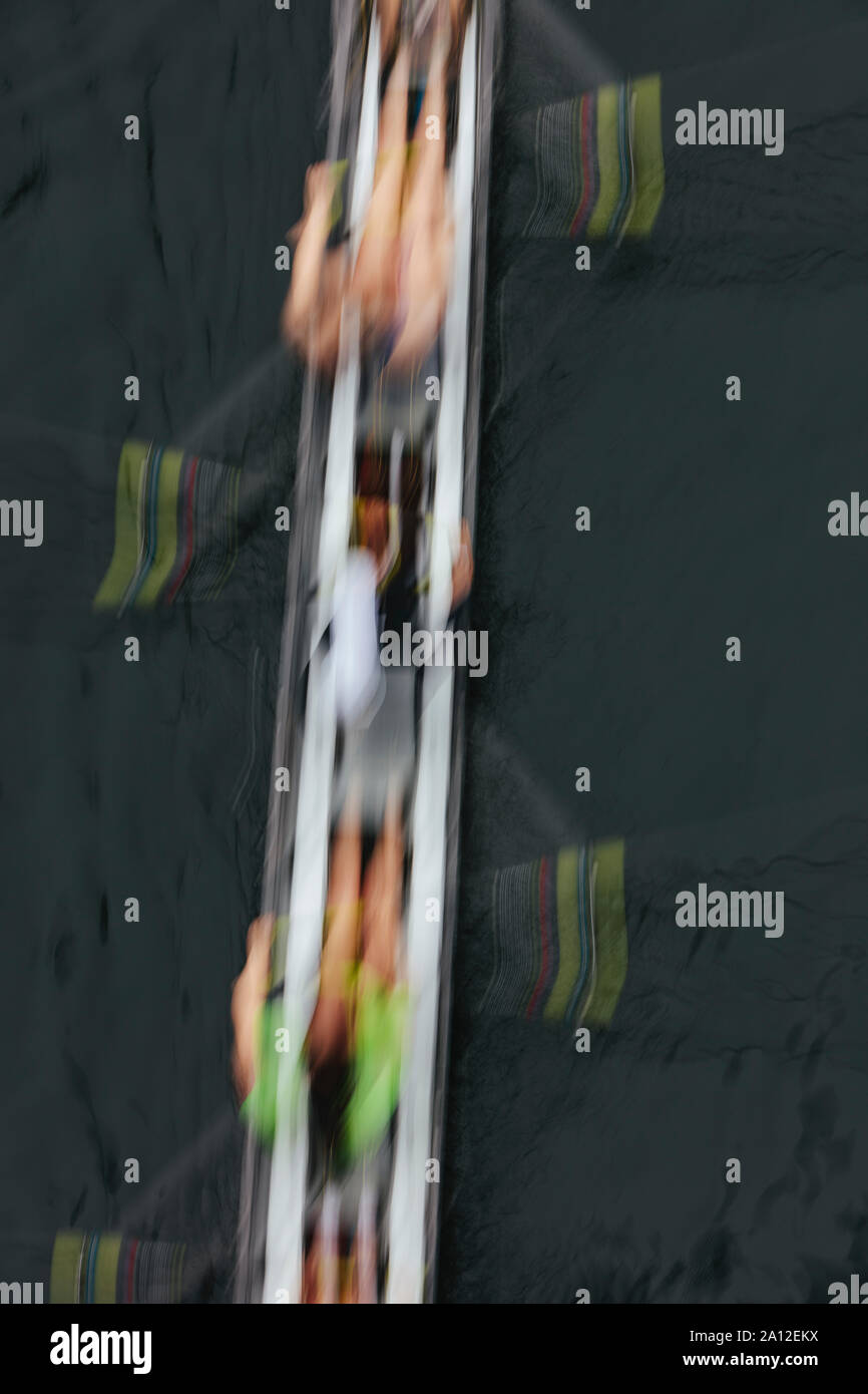 Blurred motion overhead view of a rowing crew in a sculling boat on the ...